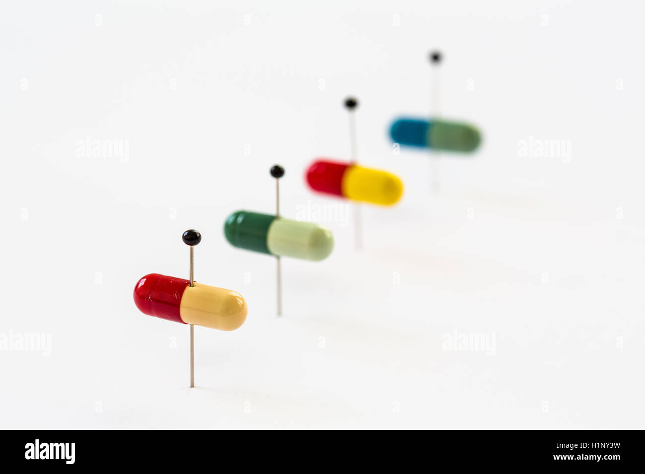 Pins stuck into capsules Stock Photo - Alamy