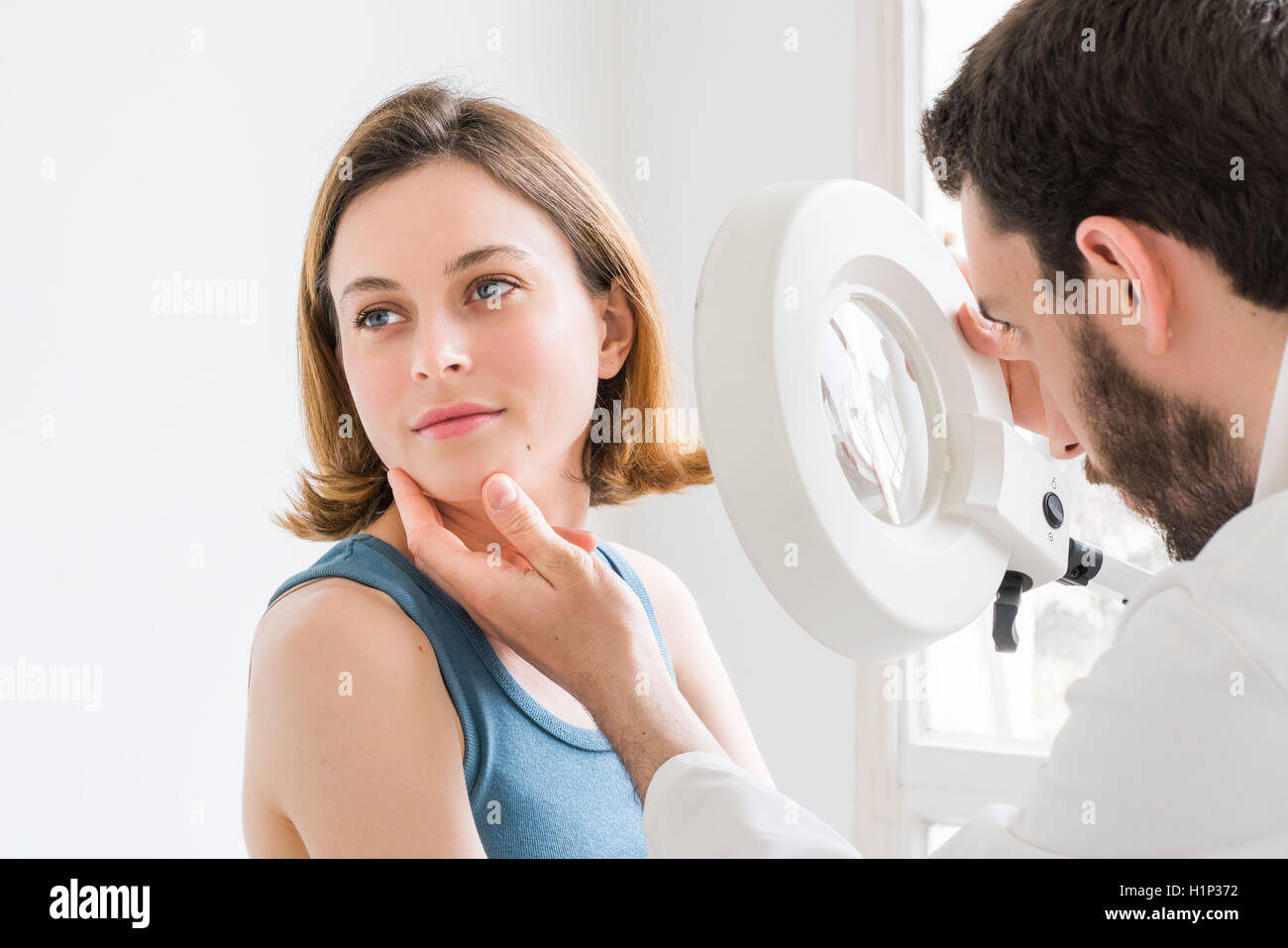 Doctor examining the skin of a woman Stock Photo - Alamy