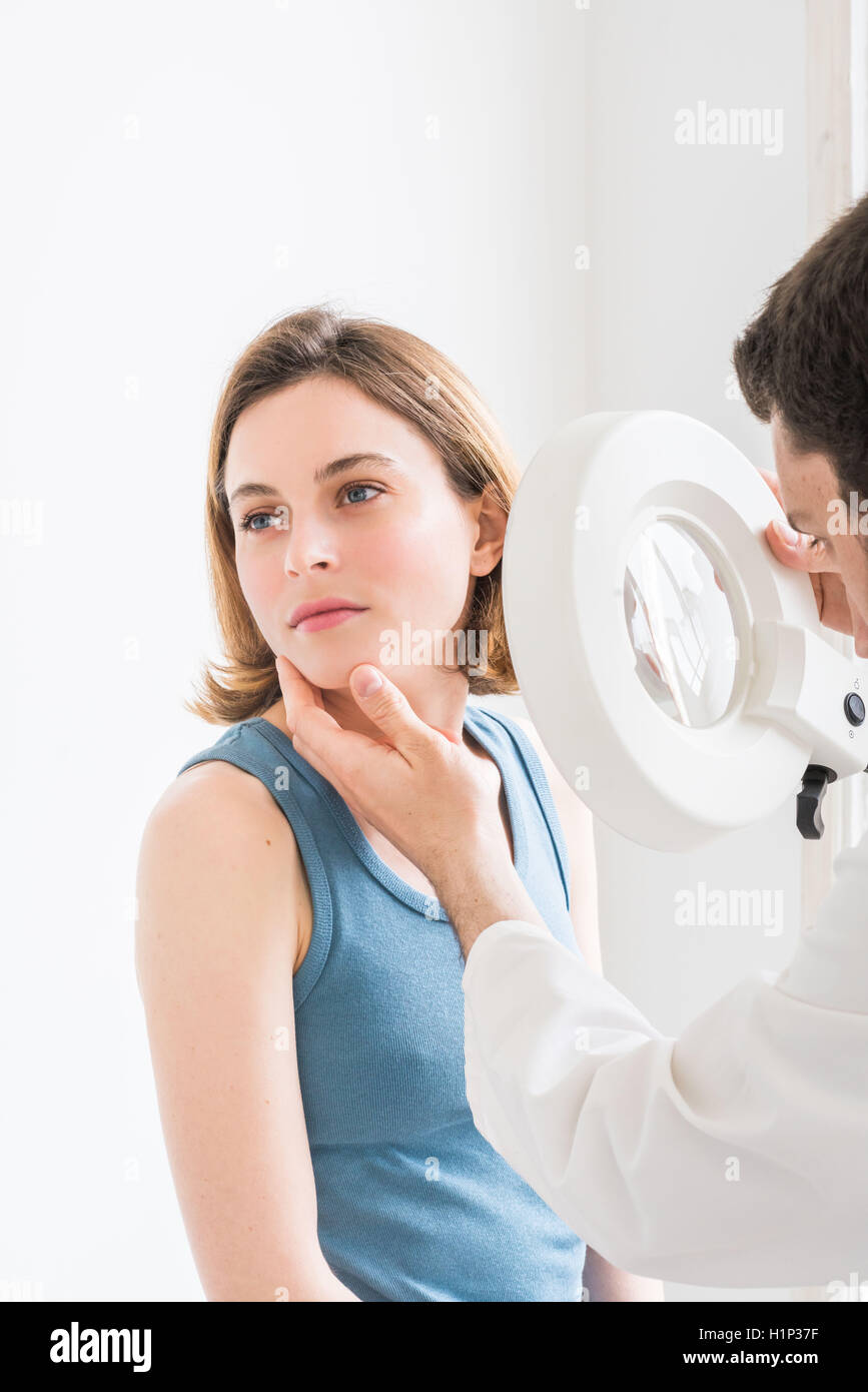 Doctor examining the skin of a woman Stock Photo - Alamy