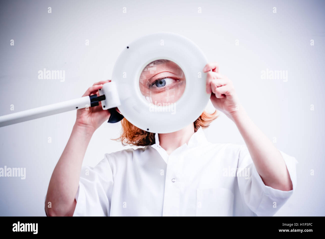 Doctor using a magnifying lamp Stock Photo - Alamy