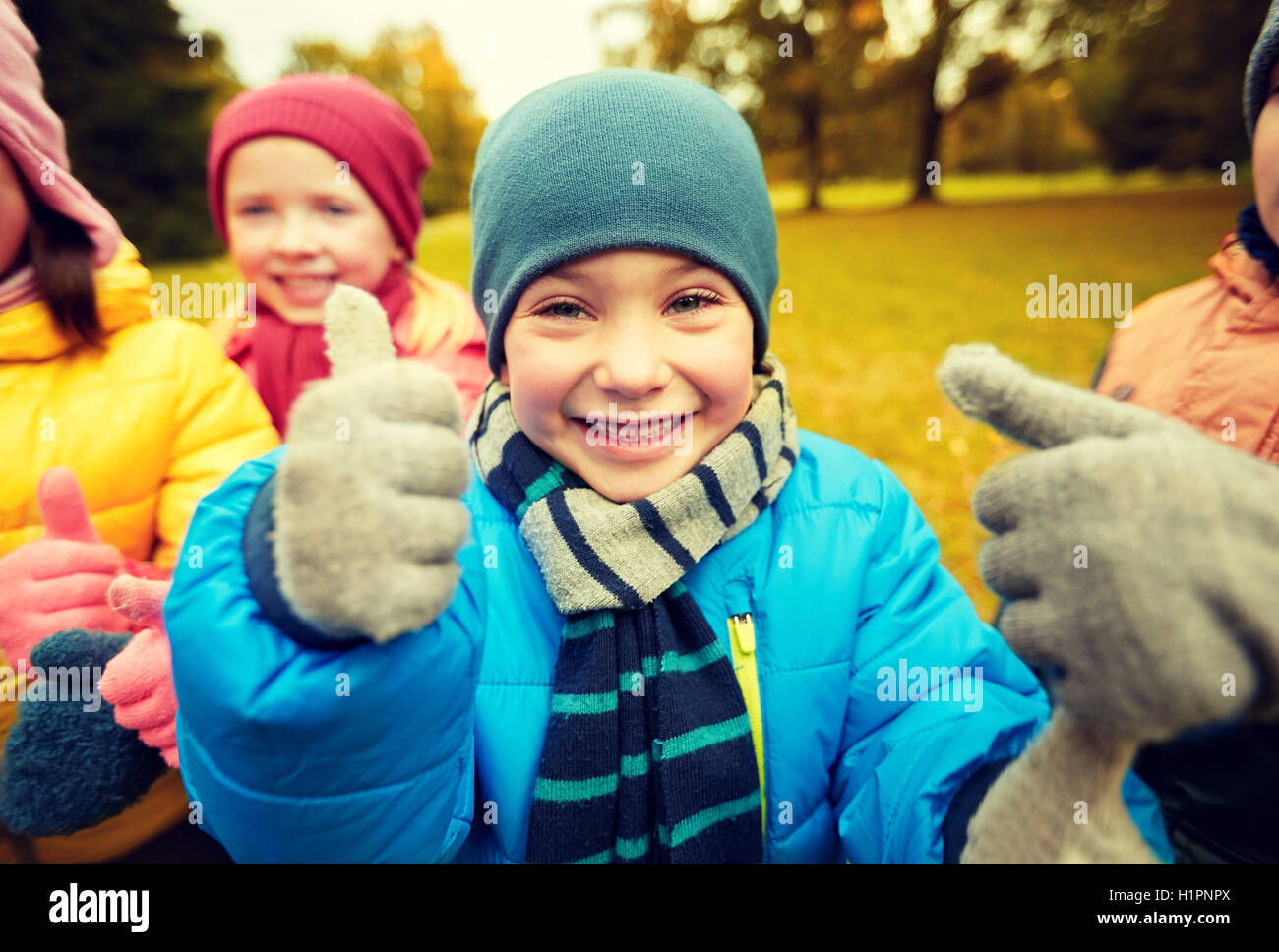 happy children showing thumbs up in autumn park Stock Photo - Alamy