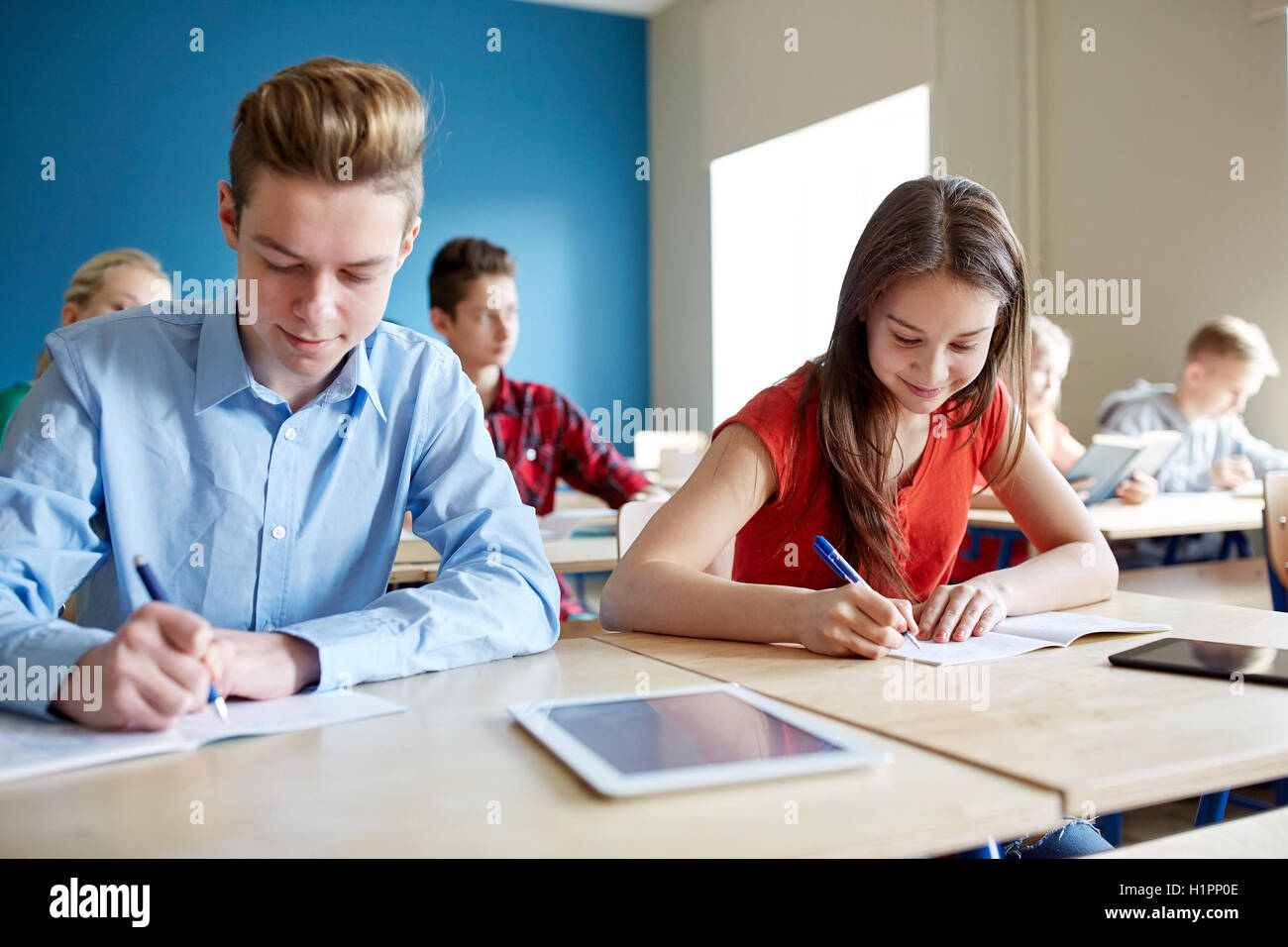 group of students with books writing school test Stock Photo - Alamy