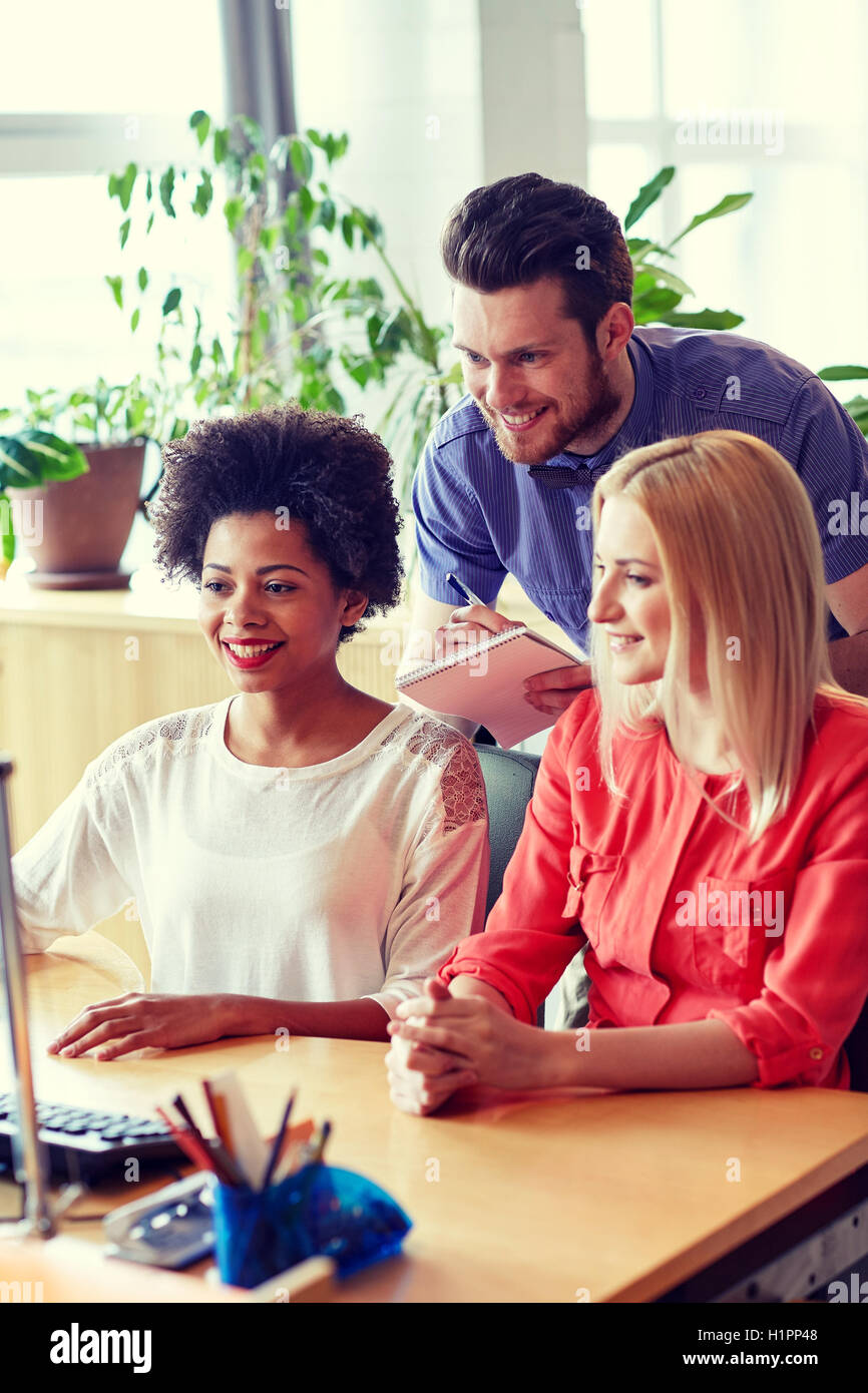 happy creative team with computer in office Stock Photo - Alamy