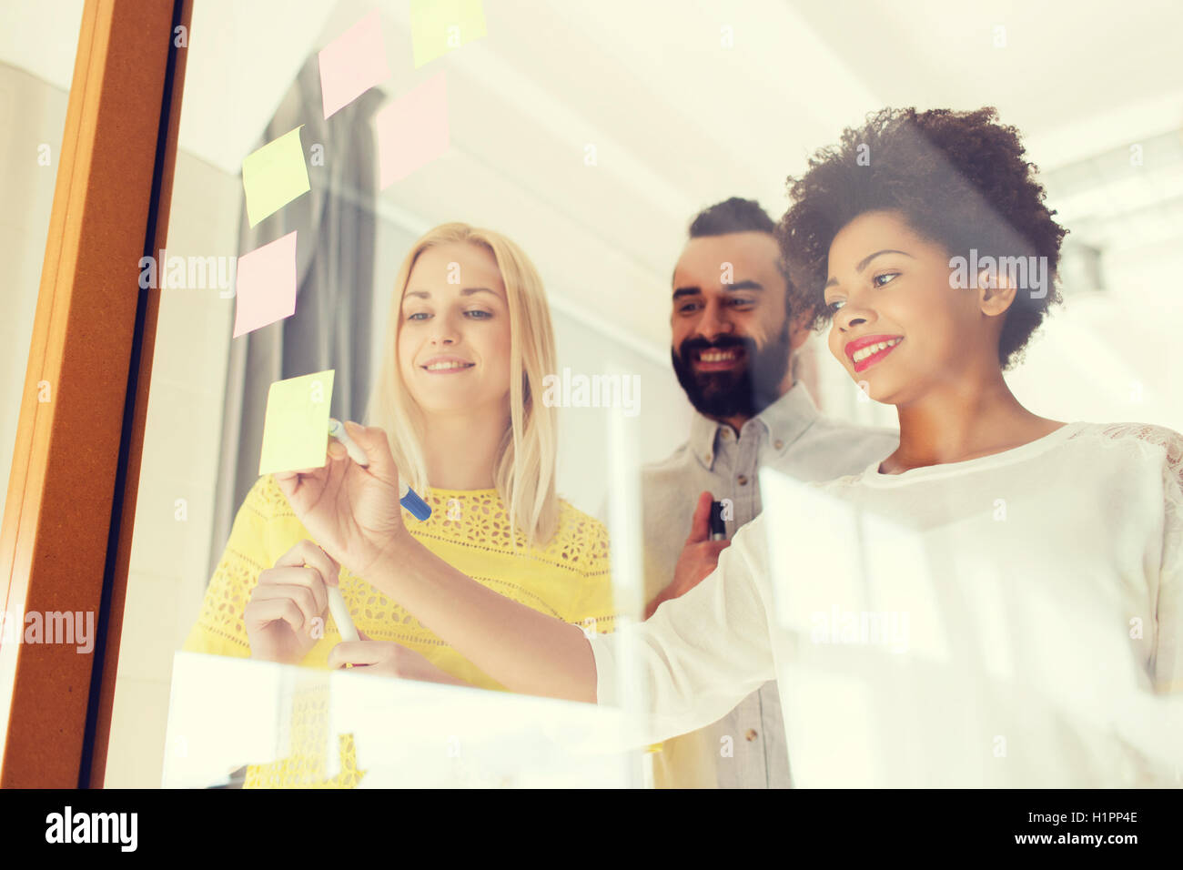 happy creative team writing on stickers at office Stock Photo - Alamy
