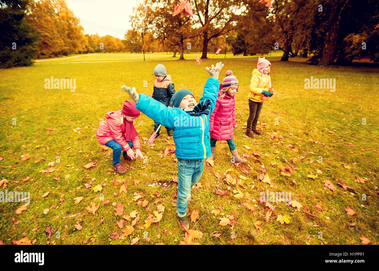 happy children playing with autumn leaves in park Stock Photo - Alamy