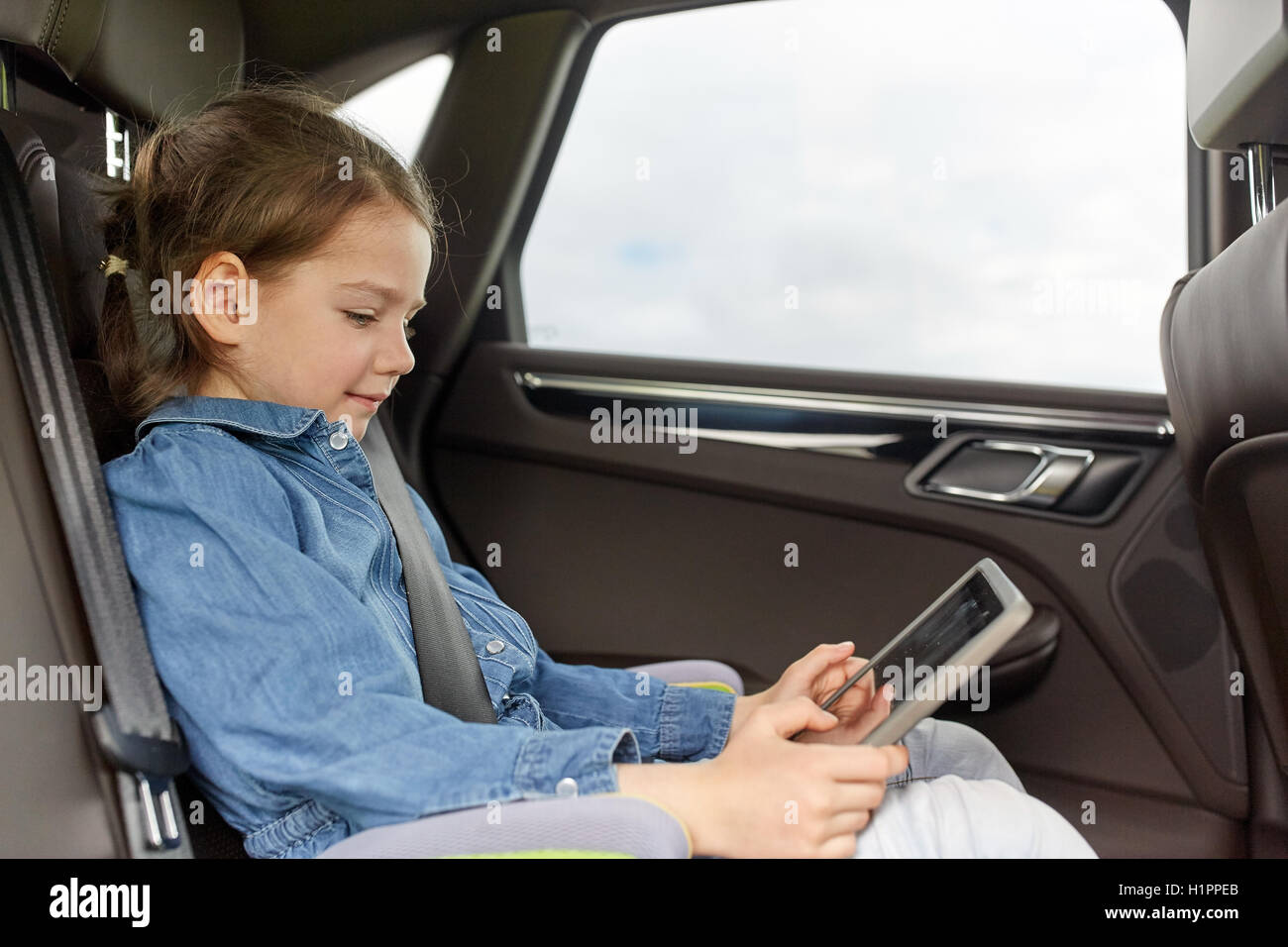 happy little girl with tablet pc driving in car Stock Photo - Alamy