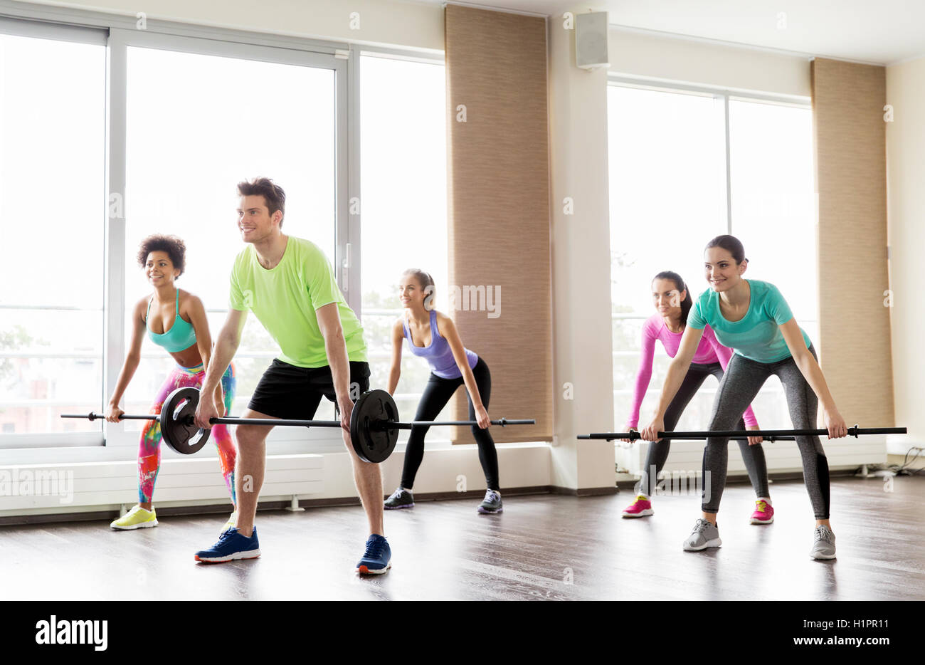happy people exercising with barbell bars in gym Stock Photo - Alamy