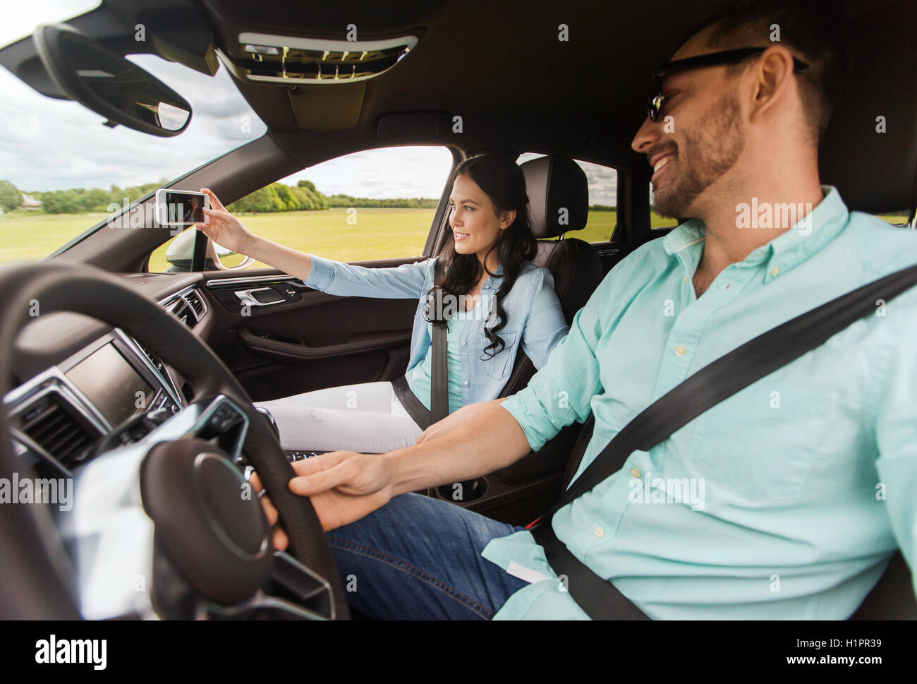 happy couple driving in car and taking selfie Stock Photo - Alamy