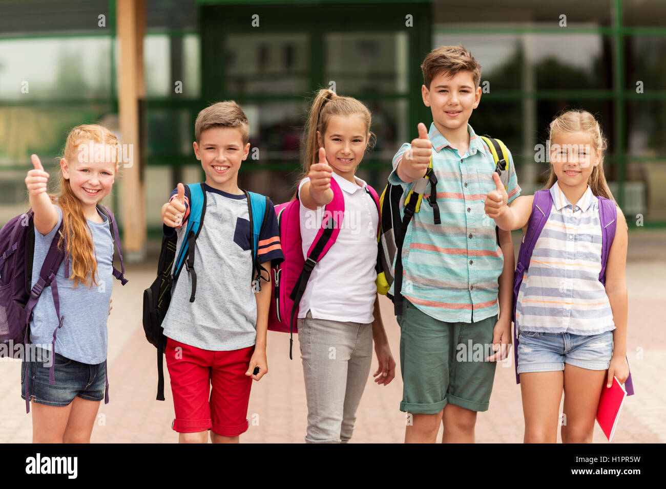 happy elementary school students showing thumbs up Stock Photo - Alamy