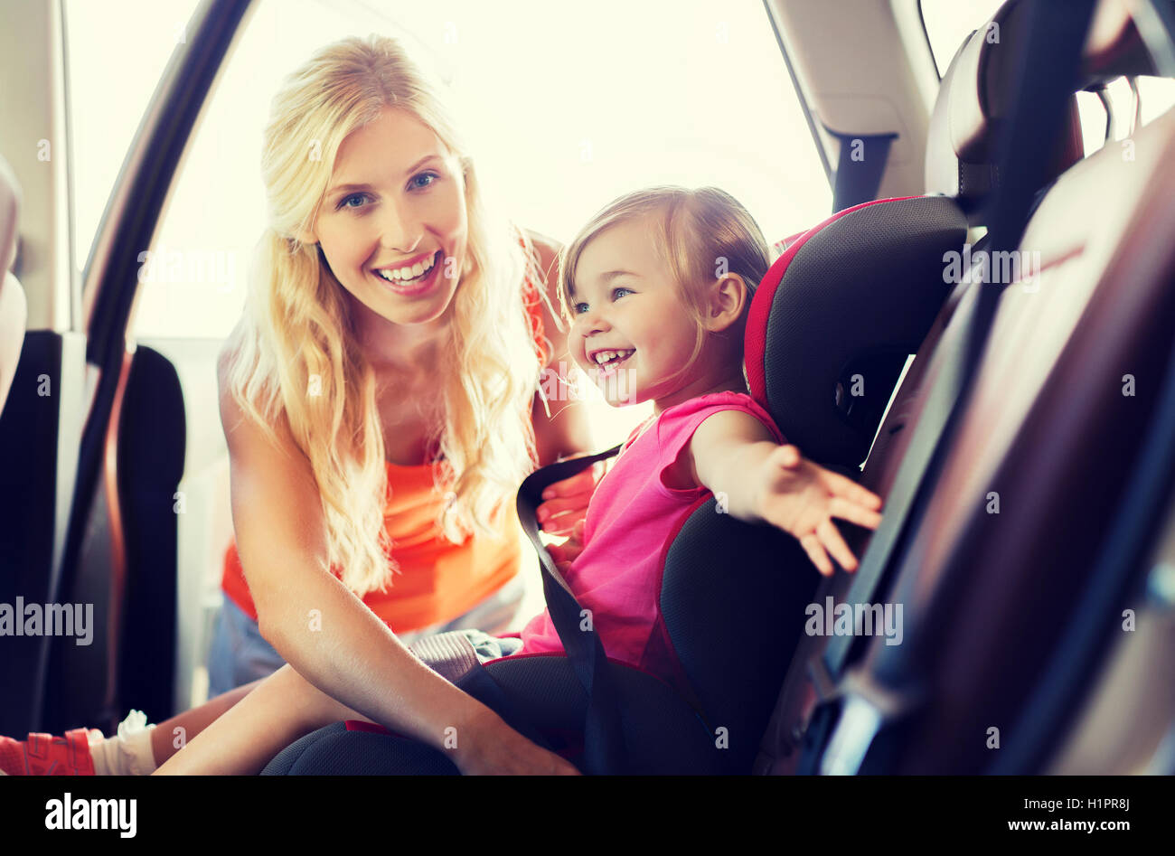 happy mother fastening child with car seat belt Stock Photo - Alamy