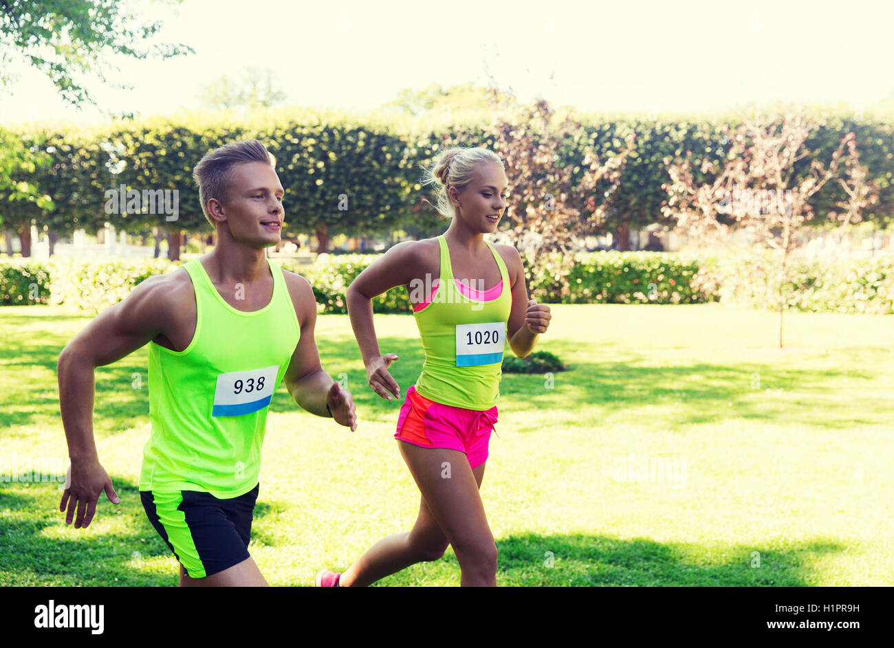 happy sportsmen couple racing wit badge numbers Stock Photo - Alamy