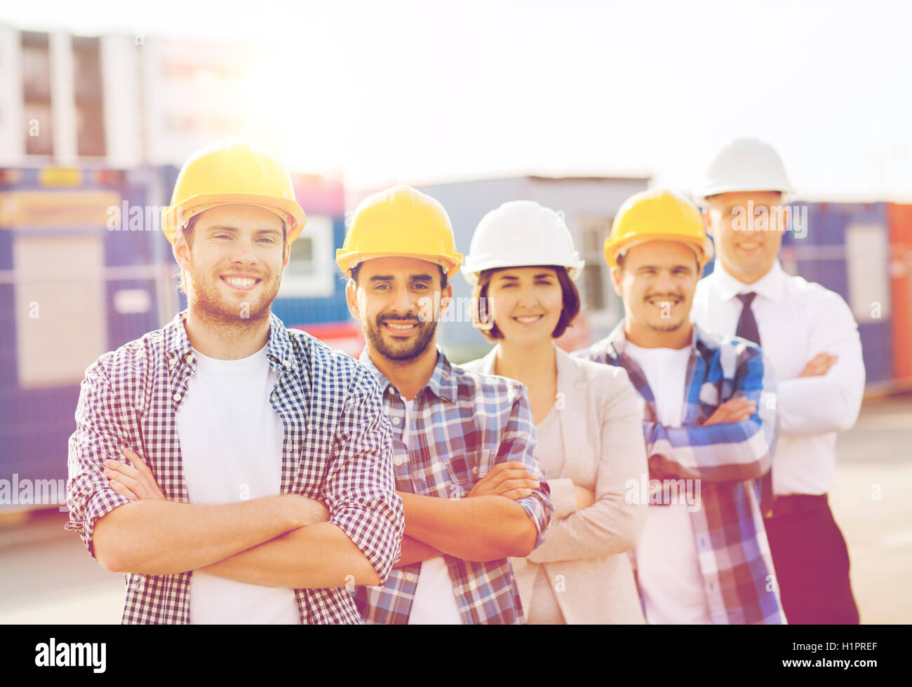 group of smiling builders in hardhats outdoors Stock Photo - Alamy