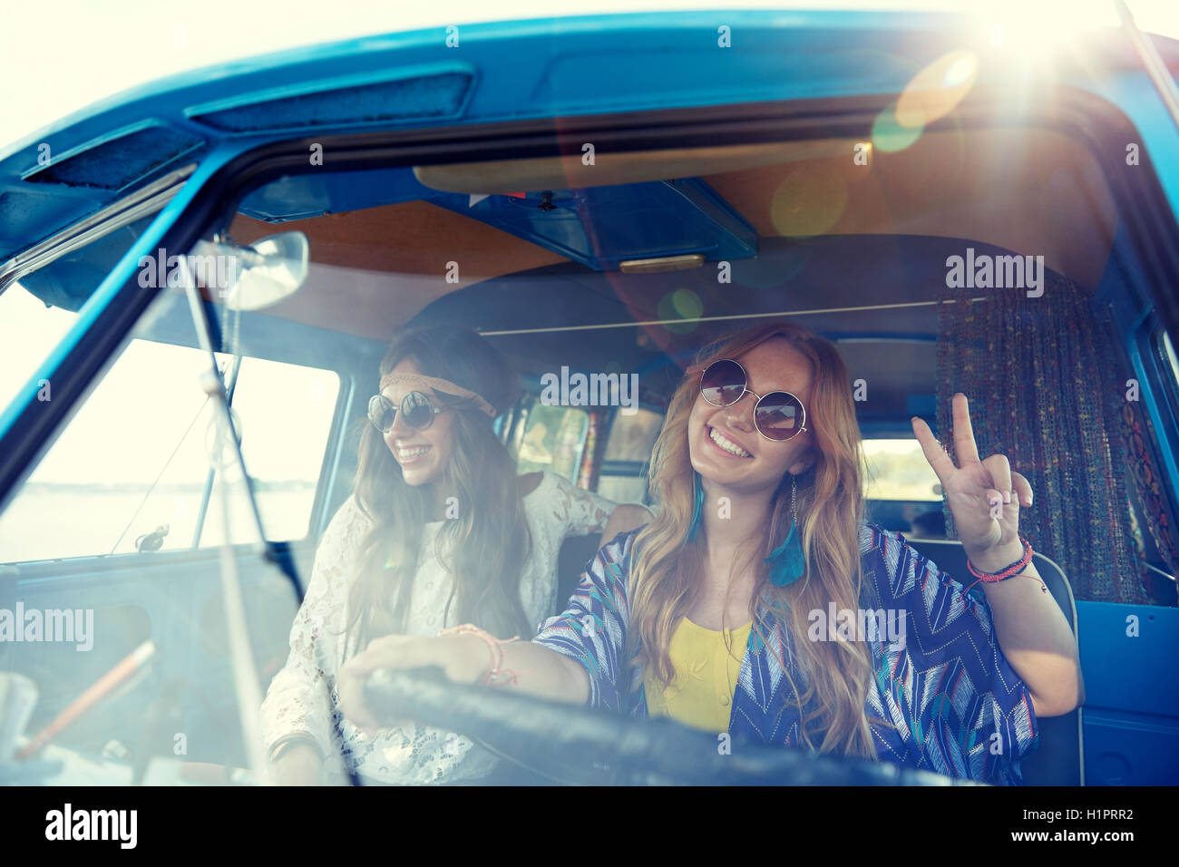 smiling young hippie women driving minivan car Stock Photo - Alamy