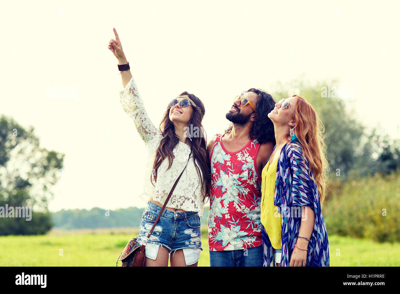happy hippie friends pointing finger outdoors Stock Photo - Alamy