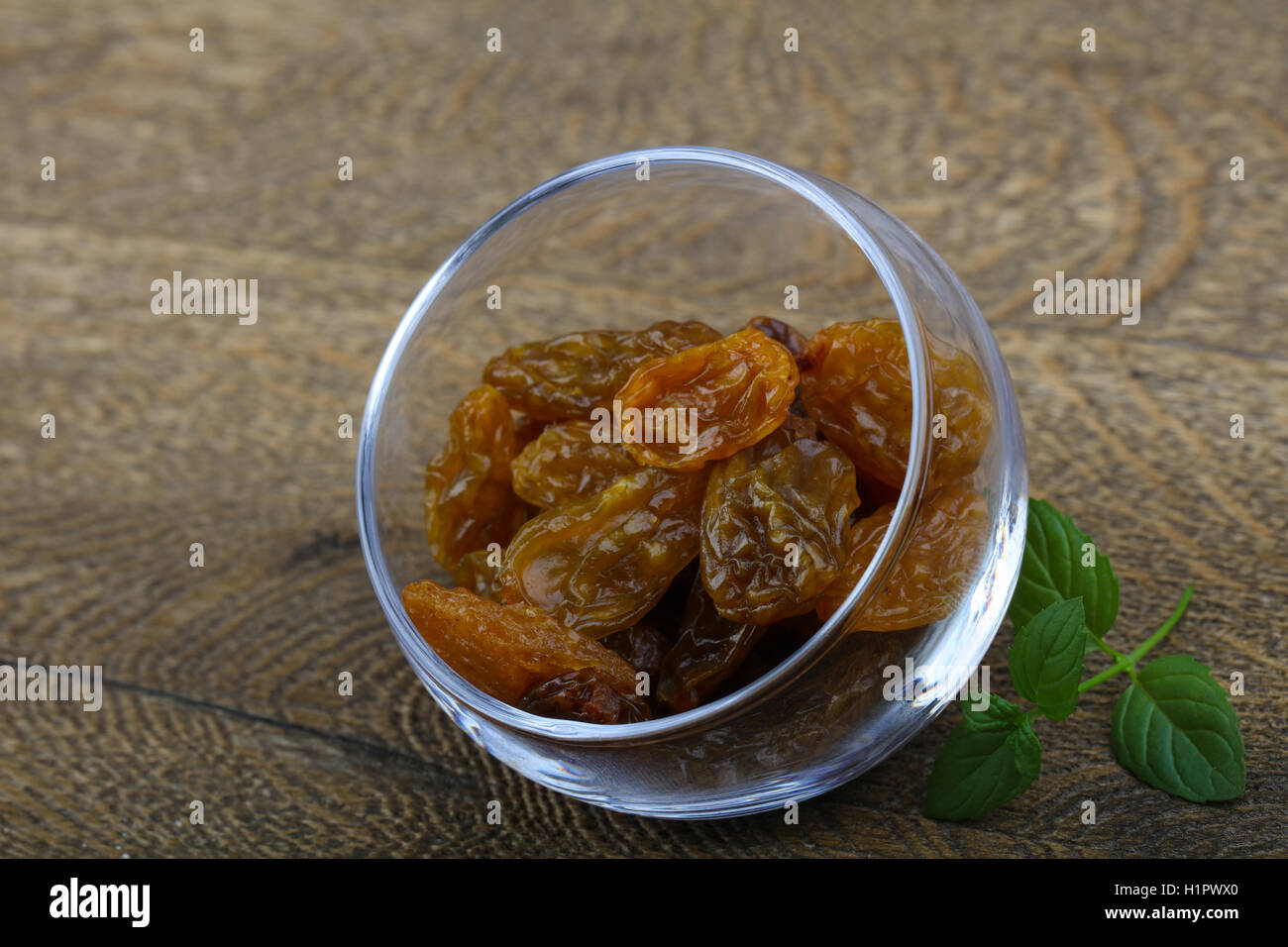Sweet raisins in the bowl with mint leaves Stock Photo - Alamy