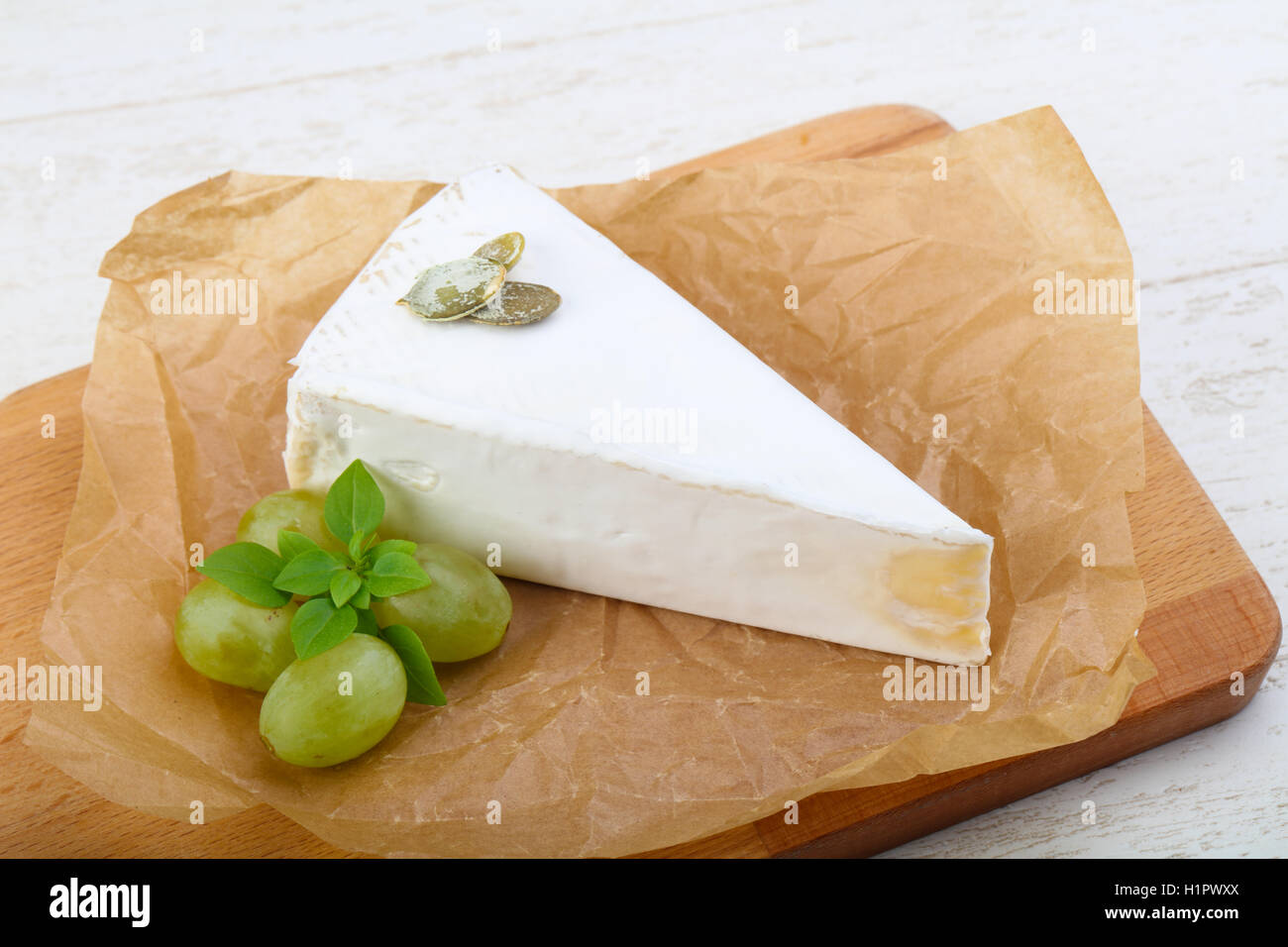 Brie cheese with grape on wood background Stock Photo - Alamy