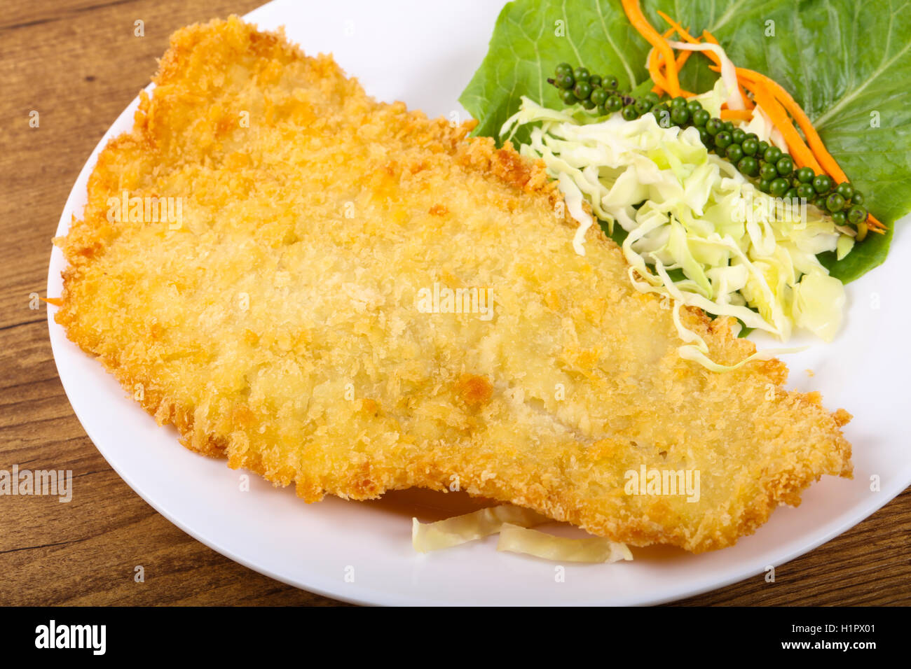 Fried Dory fish with salad on the wood background Stock Photo - Alamy
