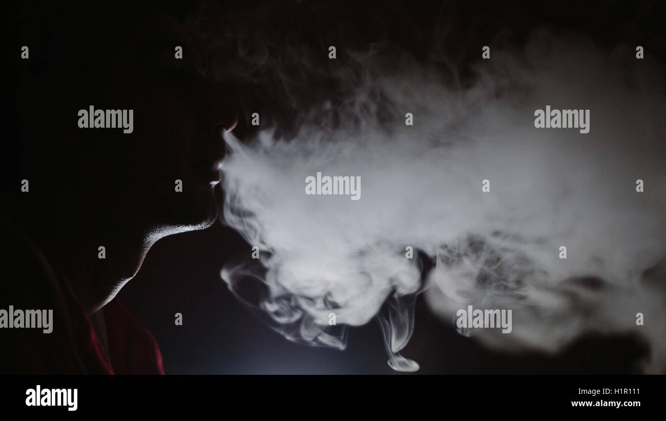 Man smokes in the dark Stock Photo - Alamy