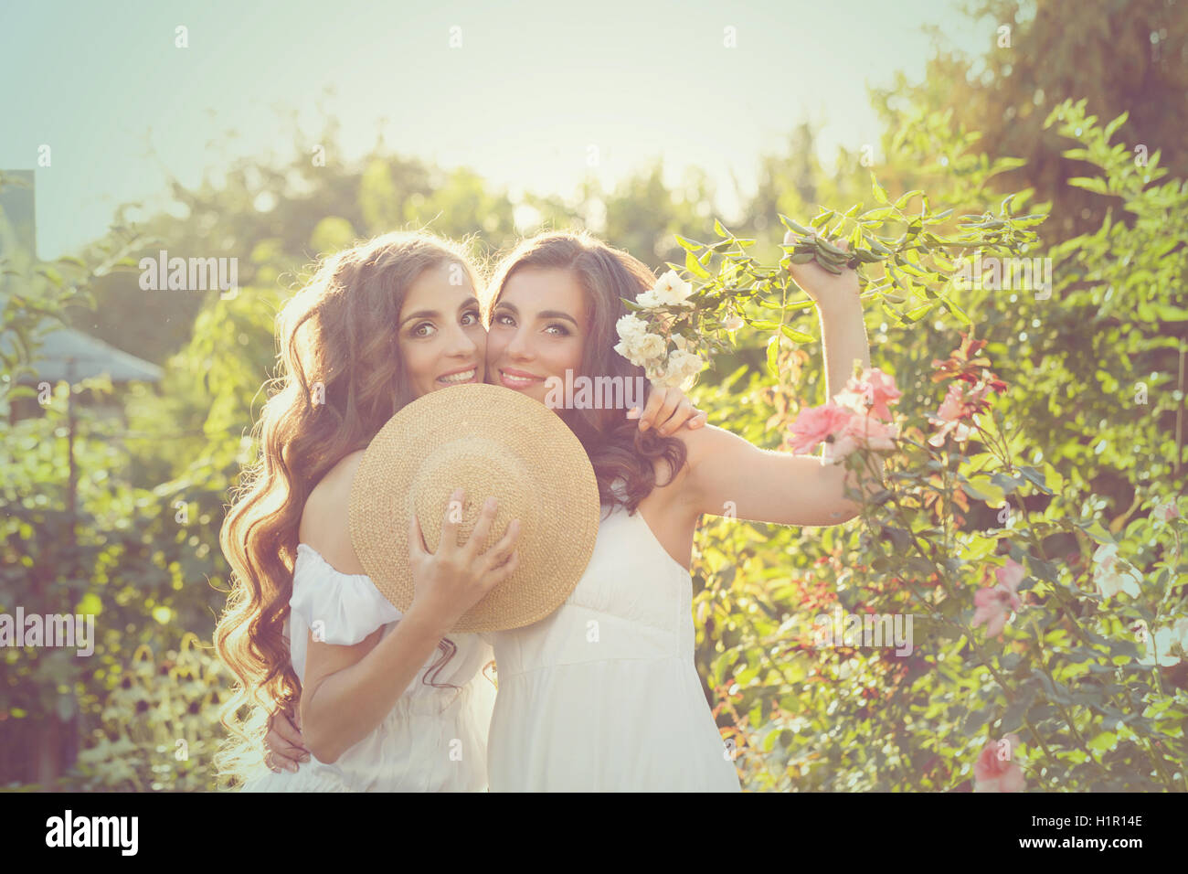Two sisters. Girls embracing in the garden. Family time. Human ...