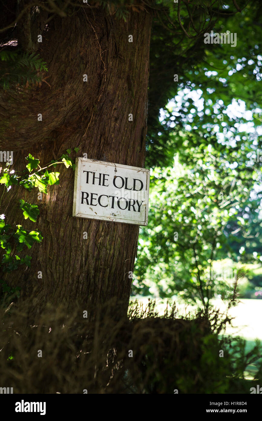 White painted sign nailed to a tree leading to a rectory near a country ...