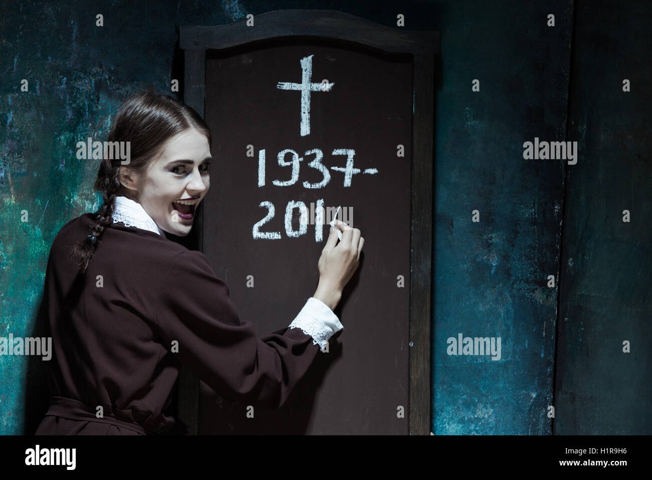 Portrait of a young smiling girl in school uniform as killer woman ...