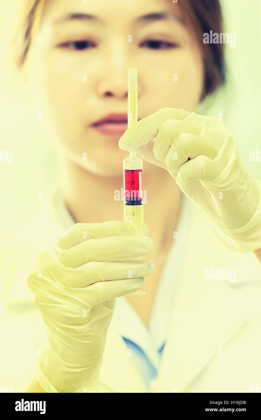 Doctor with red vaccine syringe in hand Stock Photo - Alamy