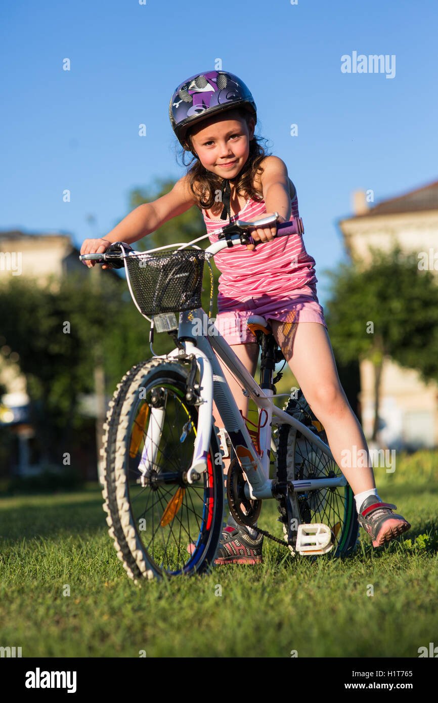 happy child girl riding bicycle in summer sunset in the park. Active kids Stock Photo - Alamy