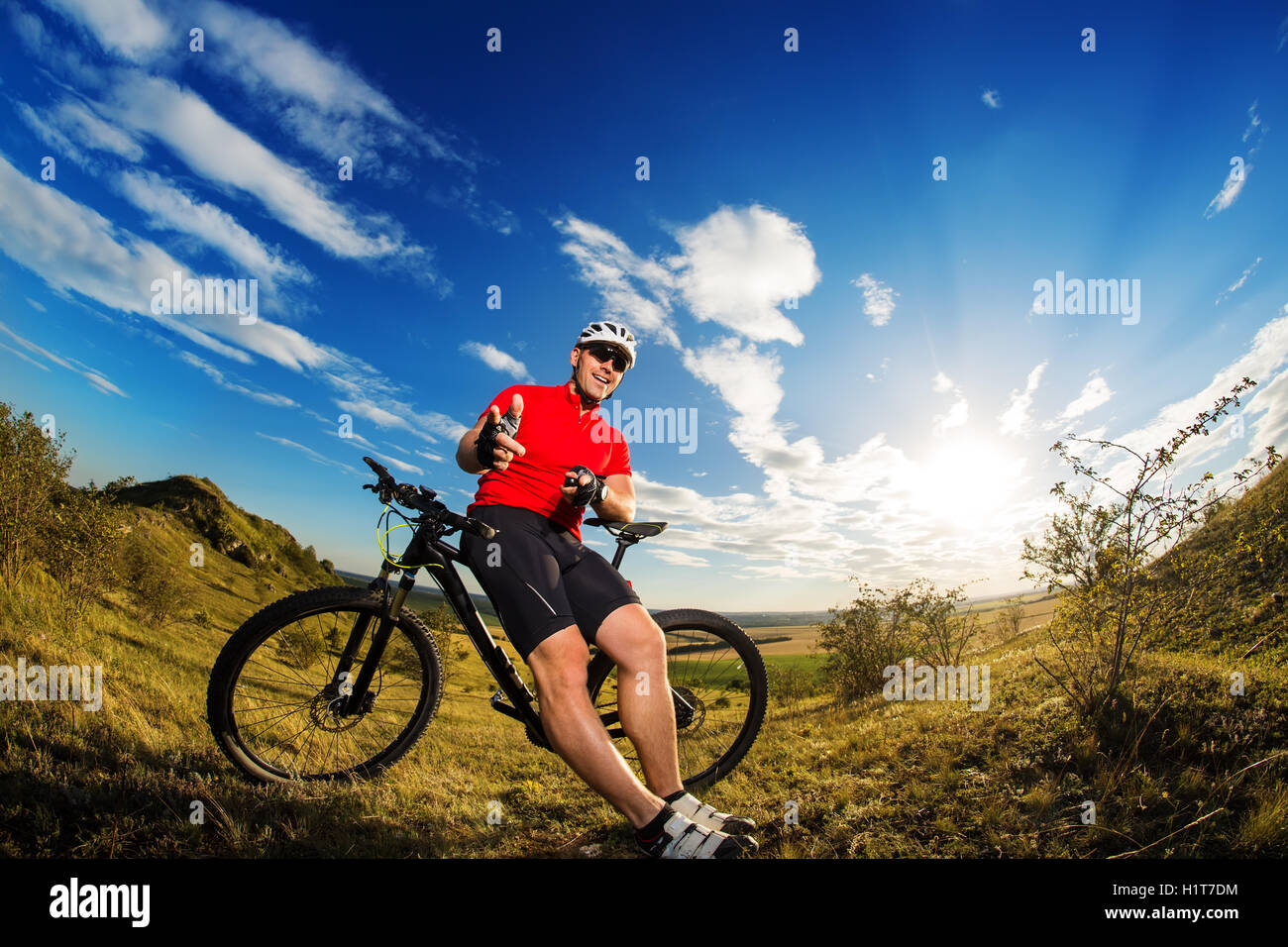 low angle view of cyclist standing with mountain bike on trail at ...