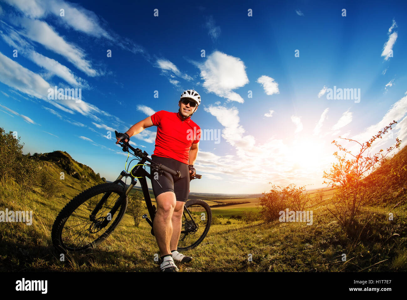 low angle view of cyclist standing with mountain bike on trail at ...