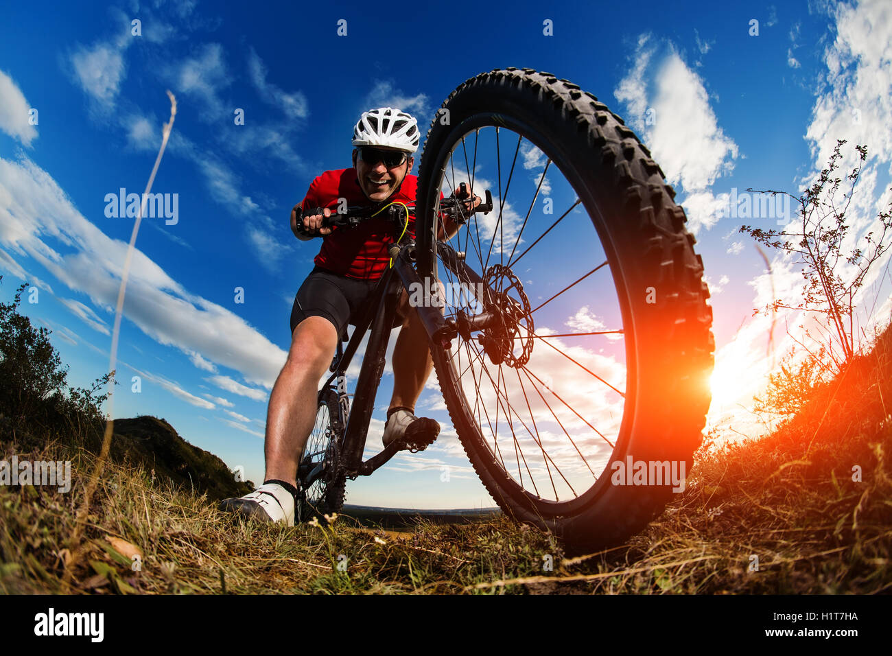 low angle view of cyclist riding mountain bike on rocky trail at ...