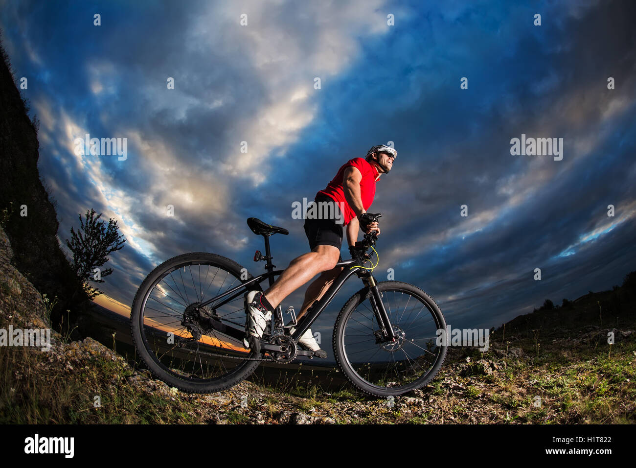 low angle view of cyclist standing with mountain bike on trail at ...
