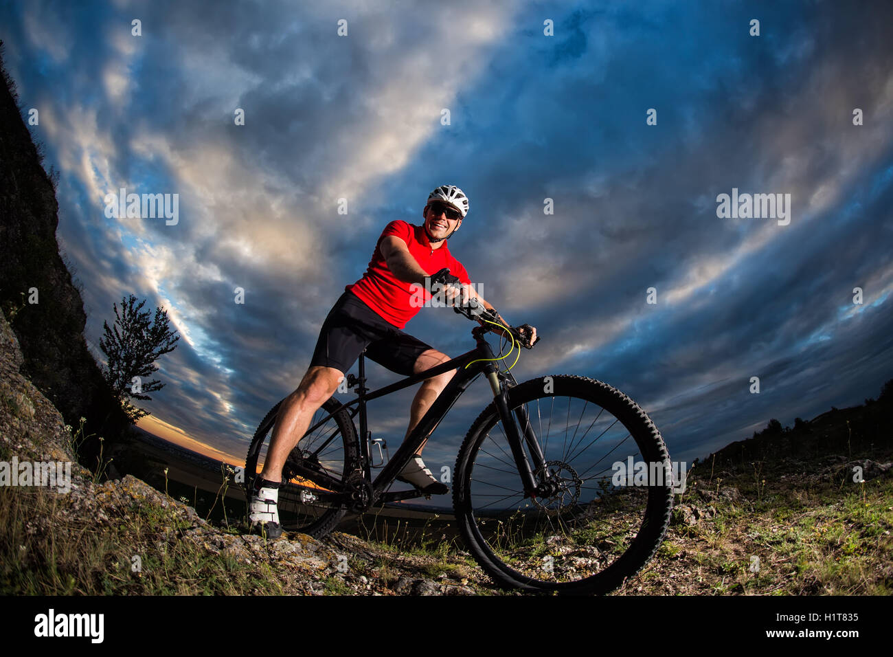 low angle view of cyclist standing with mountain bike on trail at ...