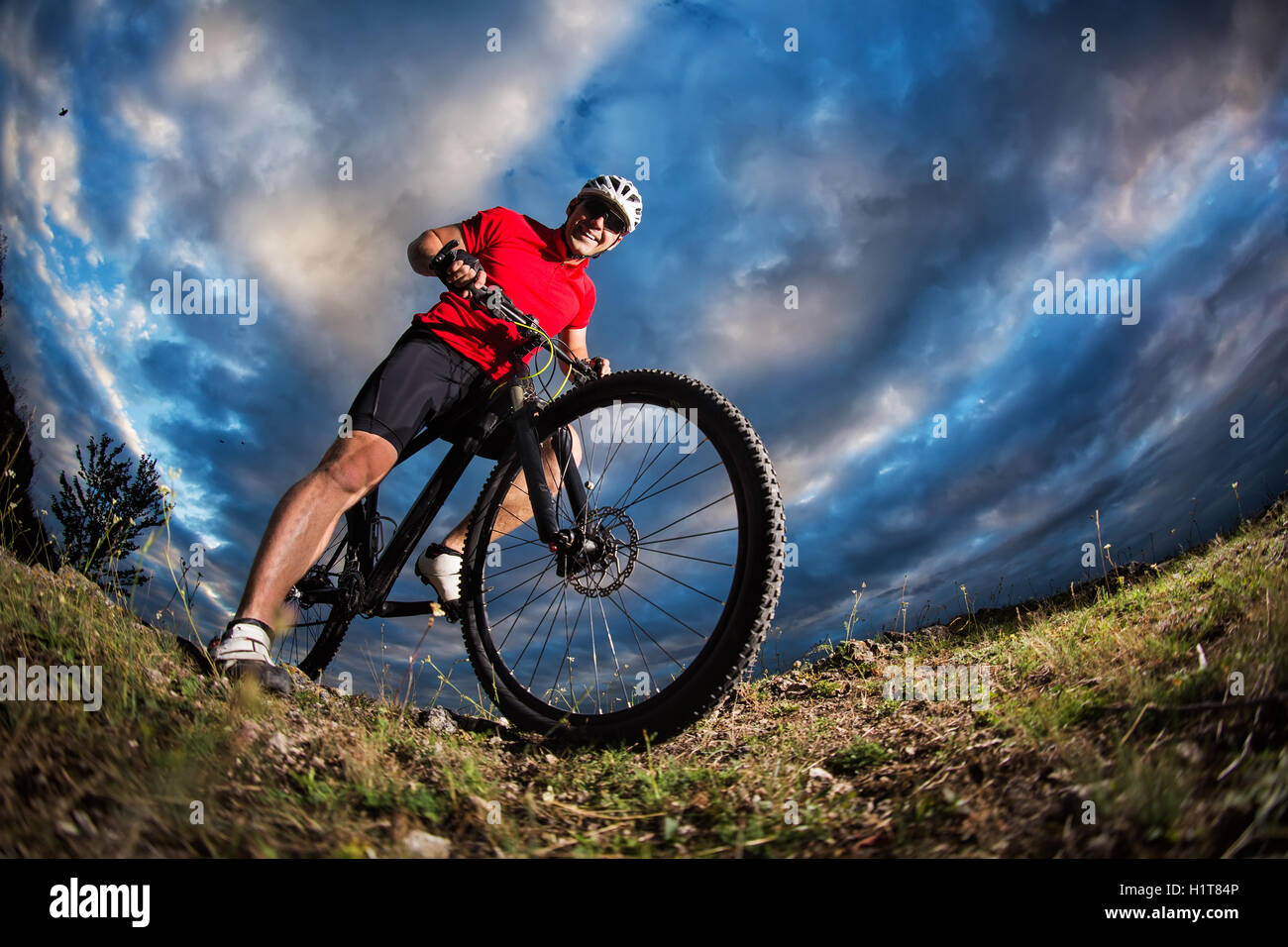 low angle view of cyclist standing with mountain bike on trail at ...