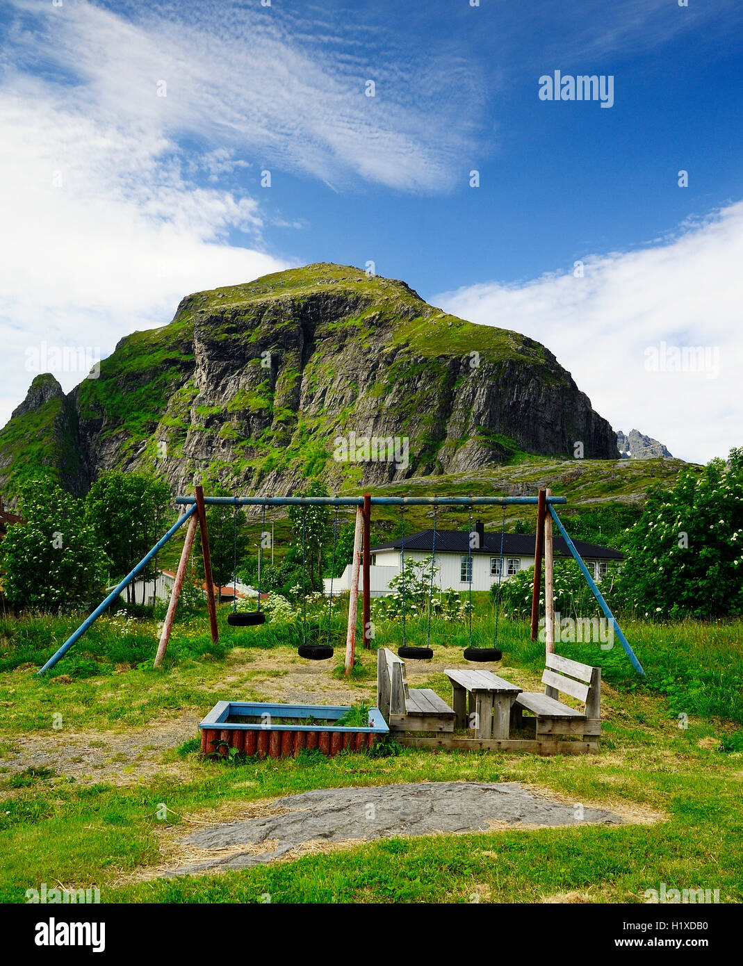 Playground and houses below the mountain Stock Photo - Alamy