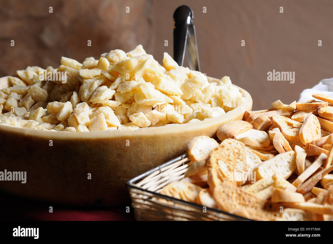 Lot of pieces of parmesan cheese and slices of toasted bread on a table ...