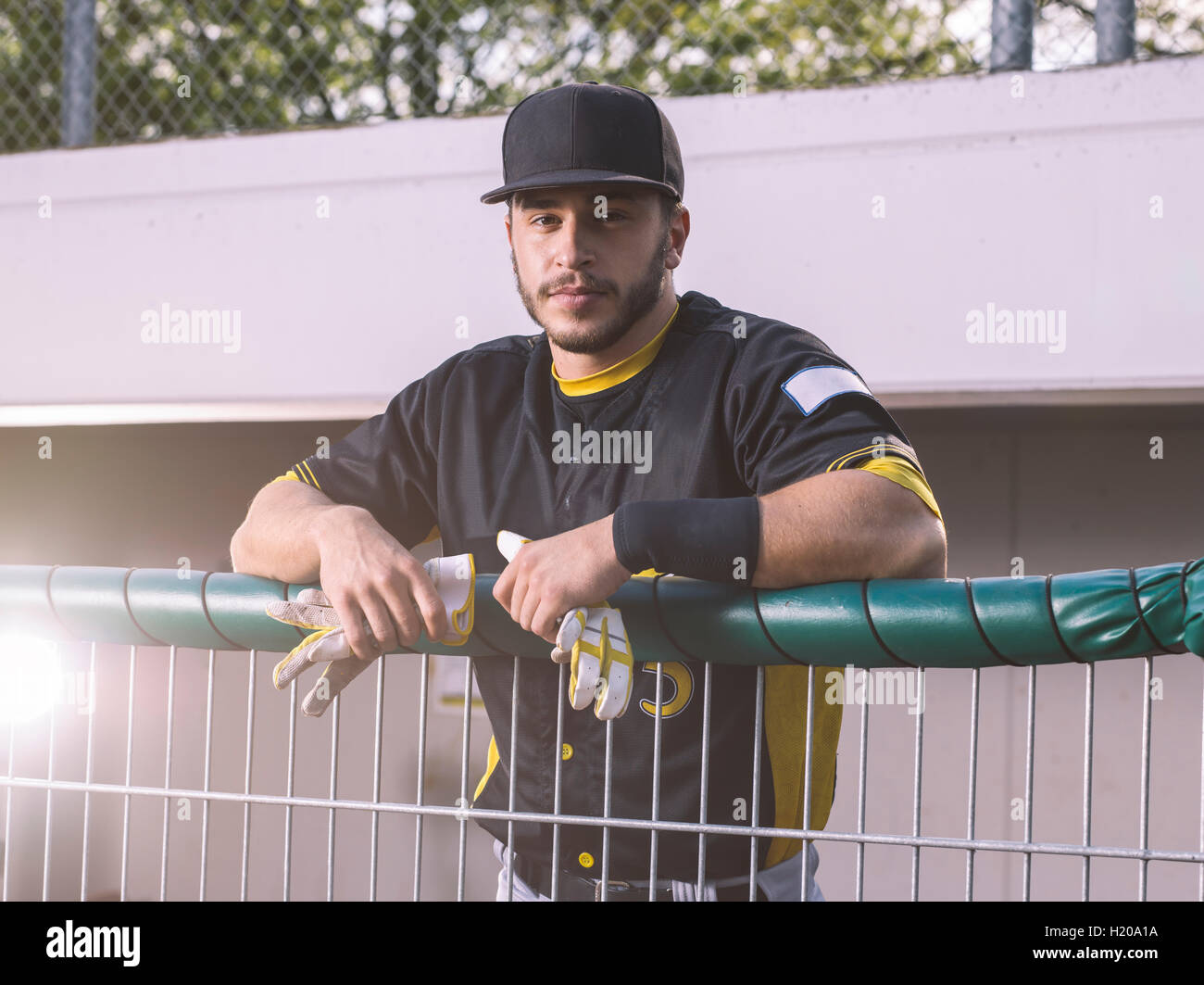 Portrait of baseball player behind fence Stock Photo - Alamy