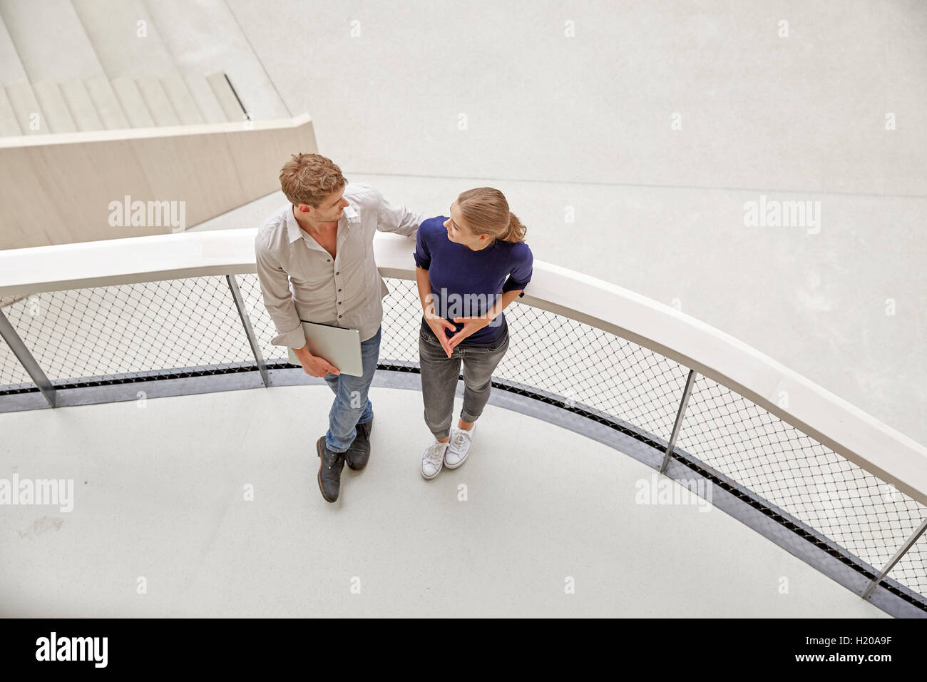 Young man and woman talking in office building Stock Photo - Alamy