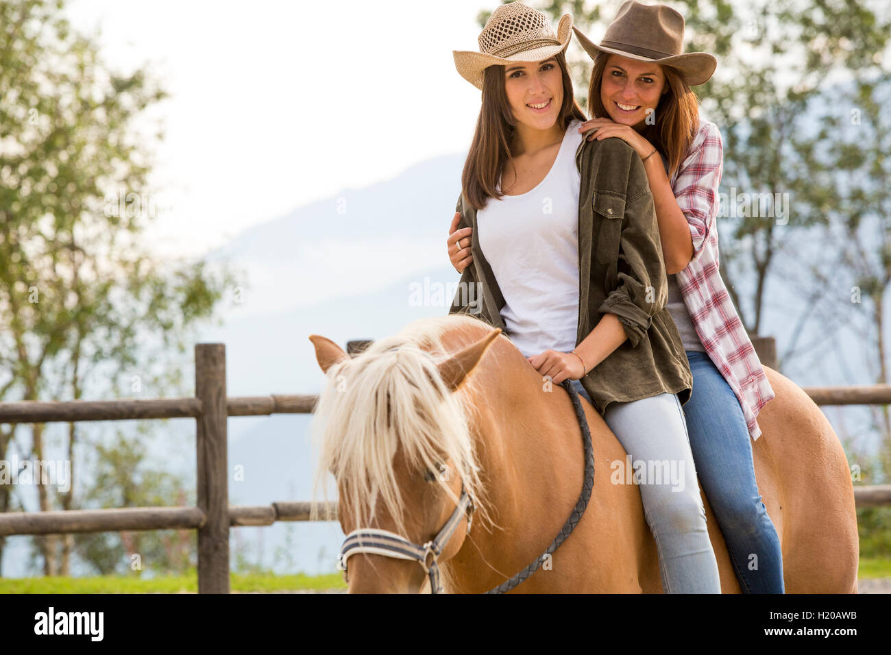 Young women riding on a horse at riding stable Stock Photo - Alamy