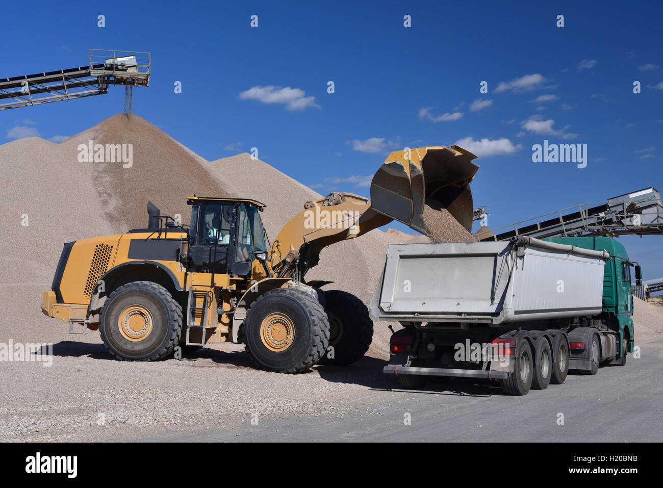Wheel loader loading gravel on truck Stock Photo - Alamy