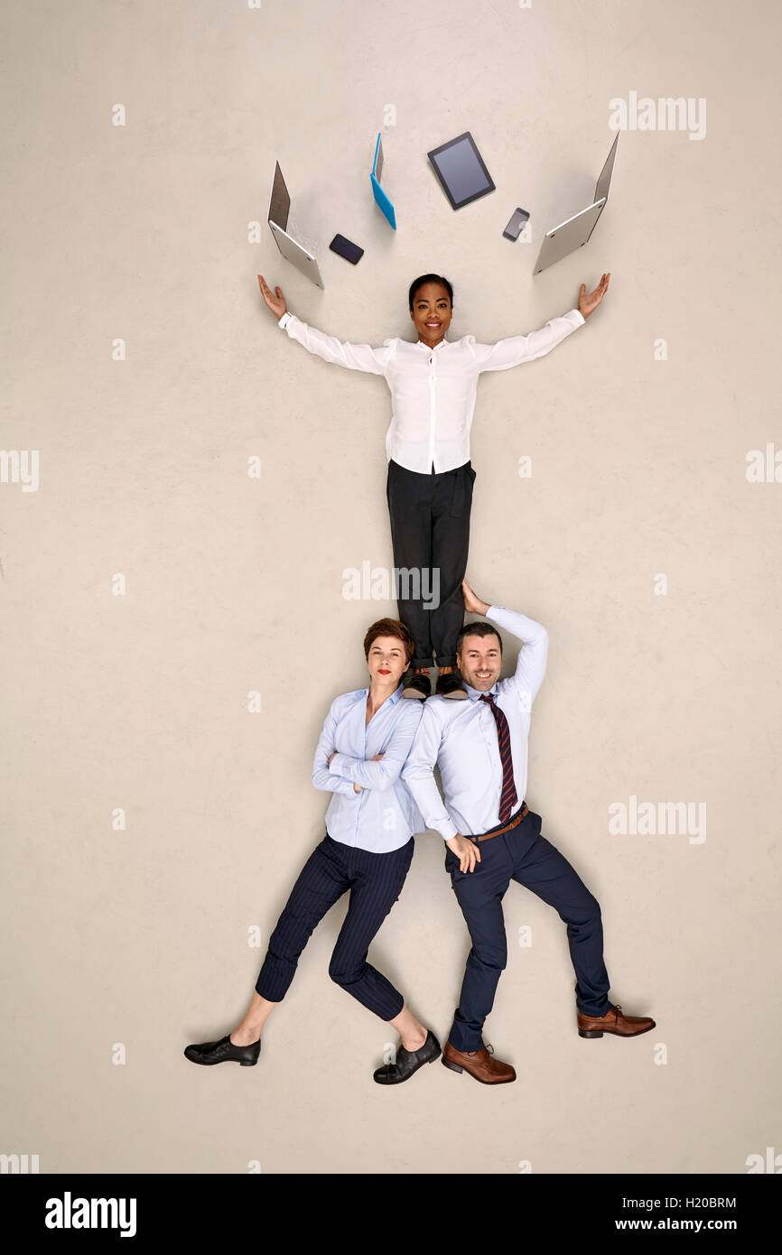 Two business people carrying colleague juggling mobile devices Stock ...