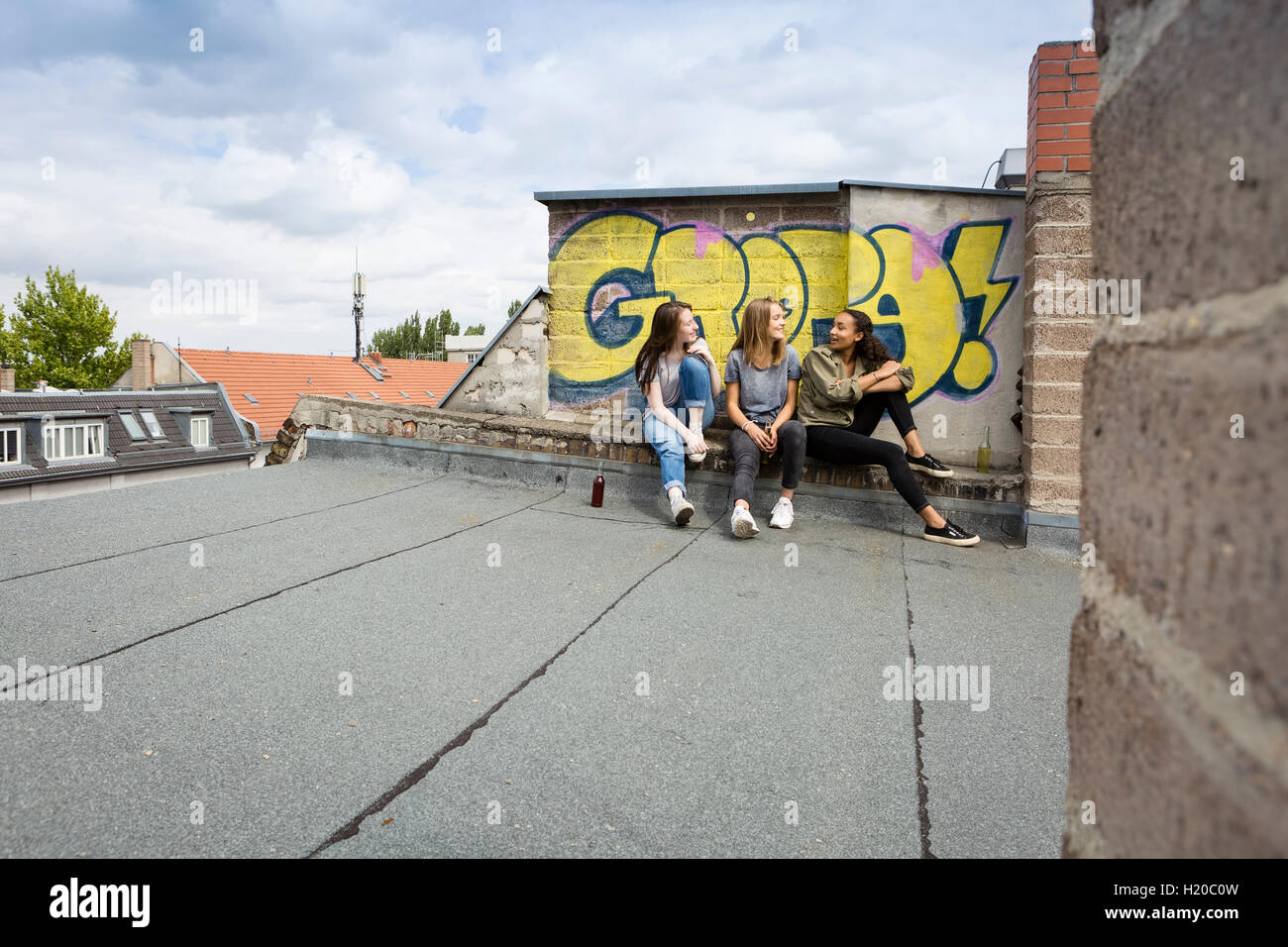 Three friends sitting on roof top hi-res stock photography and images ...