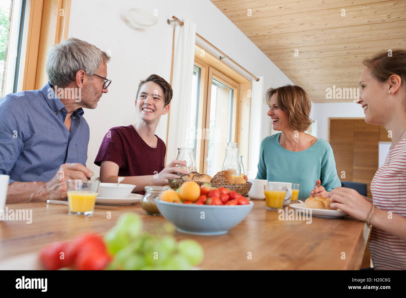 Happy family having breakfast at home Stock Photo - Alamy