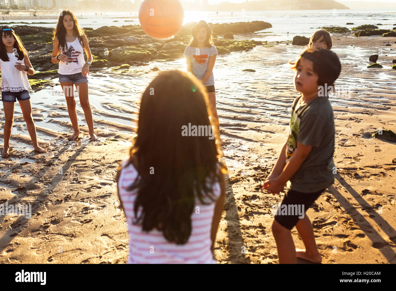 Kids playing with a ball on the beach at sunset Stock Photo - Alamy