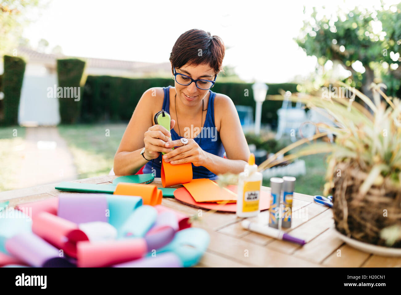 Woman doing handicrafts at garden table Stock Photo - Alamy