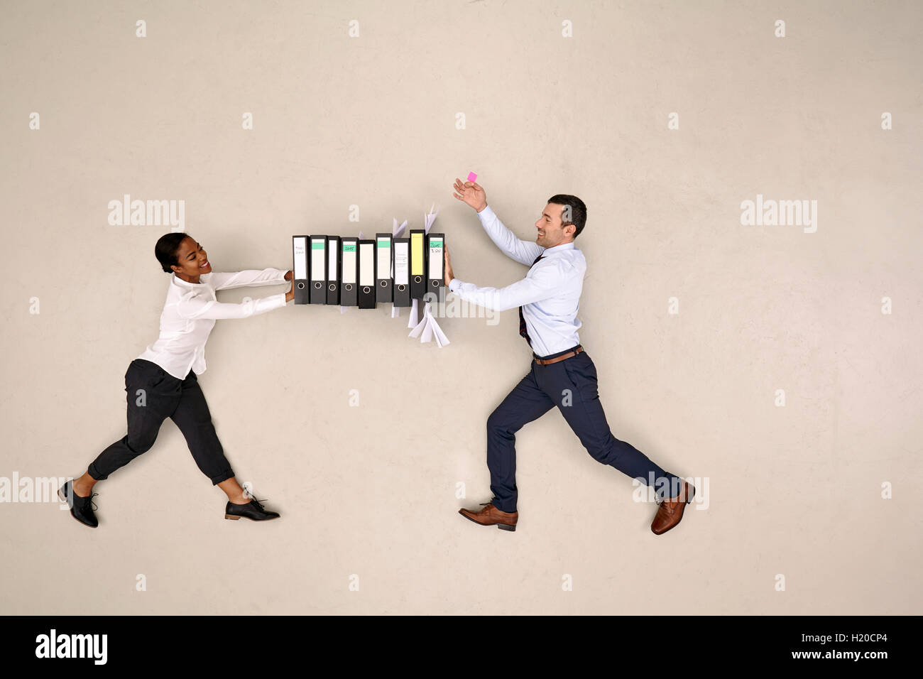 Two colleagues pushing folders together Stock Photo - Alamy