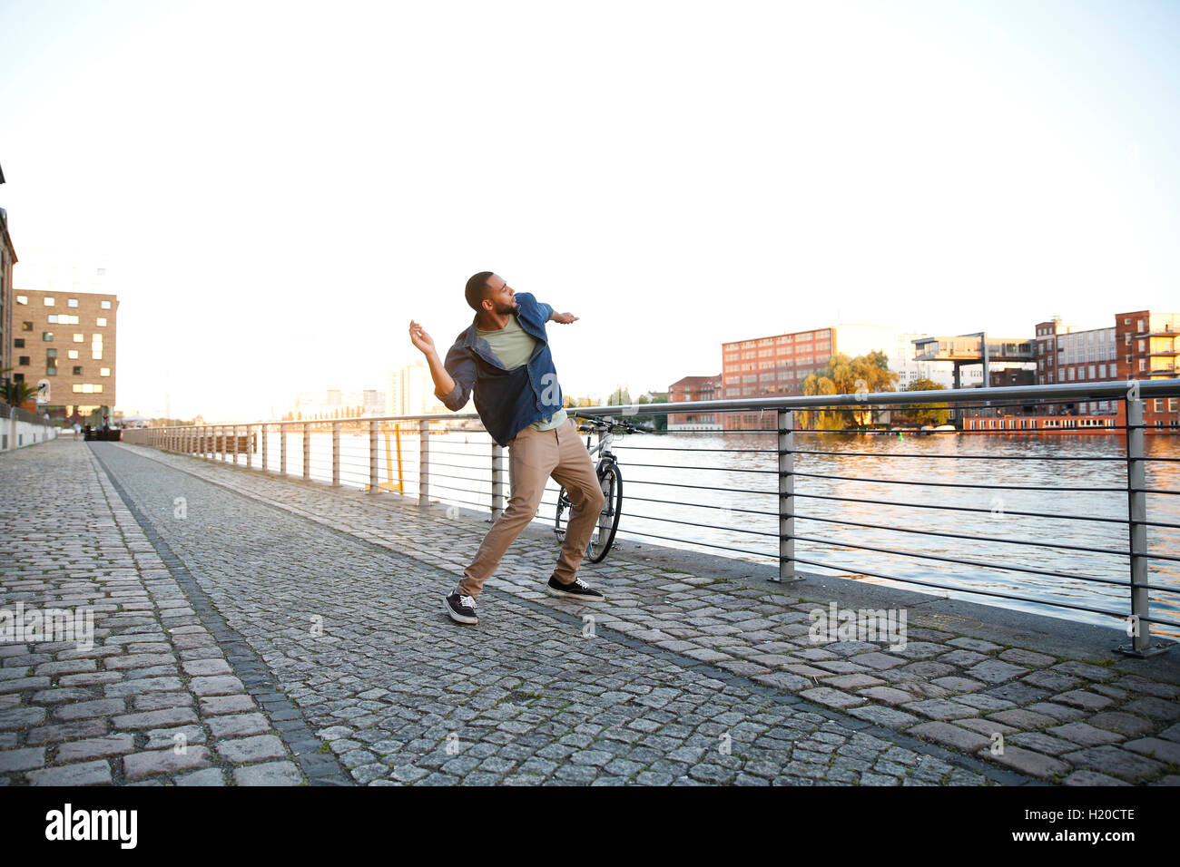 Young man throwing stone into river Stock Photo - Alamy