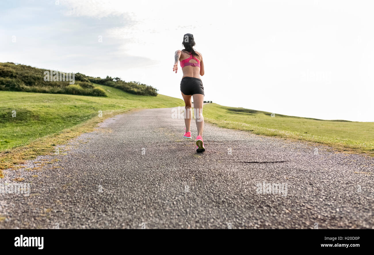 Female runner training on country road Stock Photo - Alamy