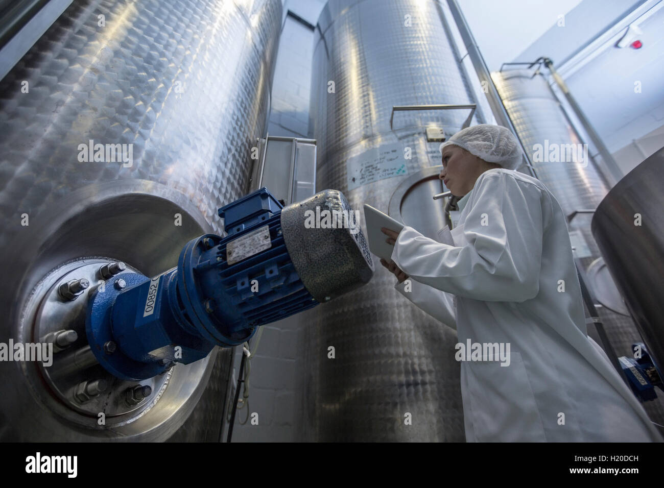 Lab technician in pharmaceutical plant in front of tanks Stock Photo ...
