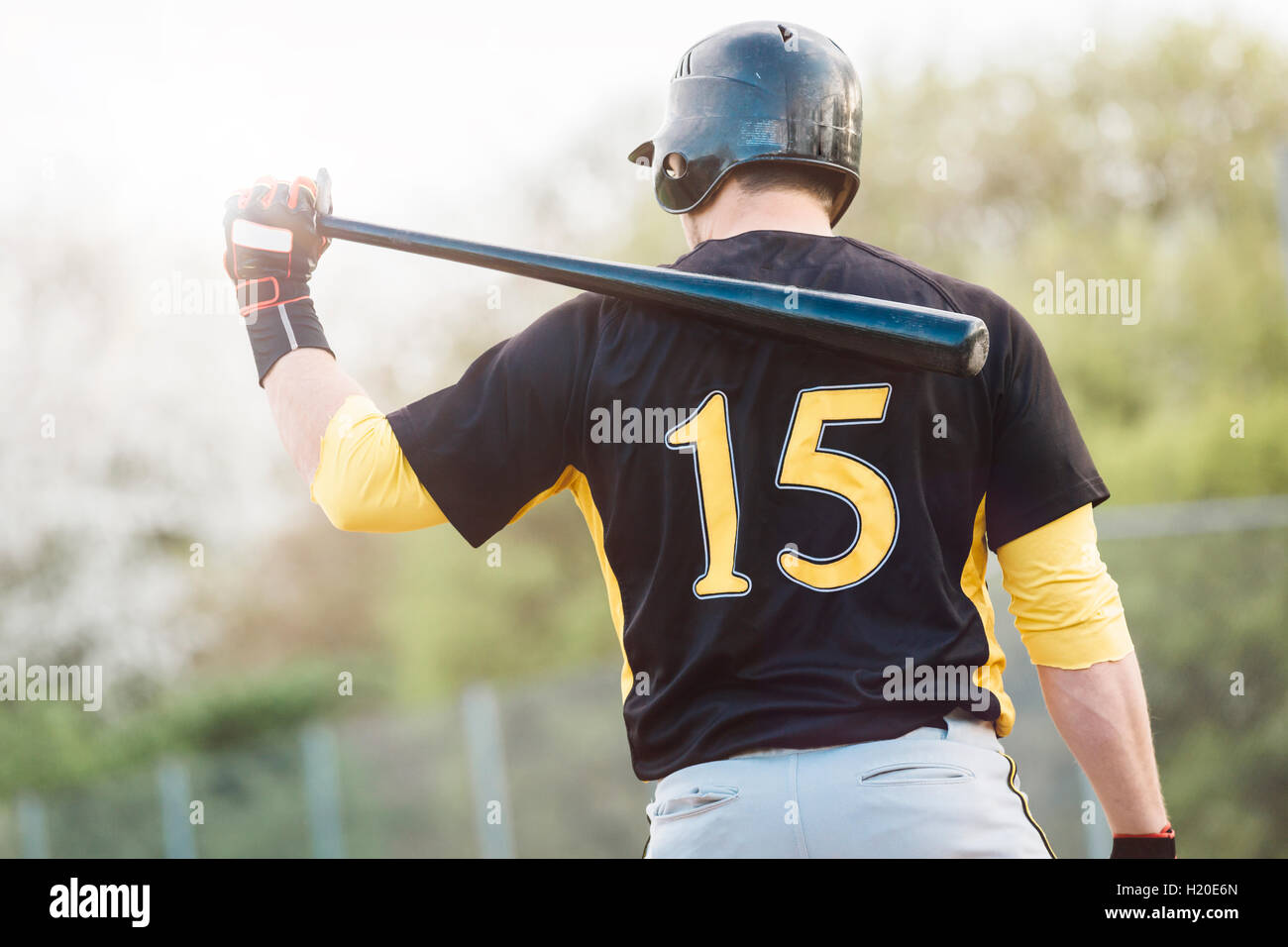 Rear view of baseball player holding bat Stock Photo - Alamy