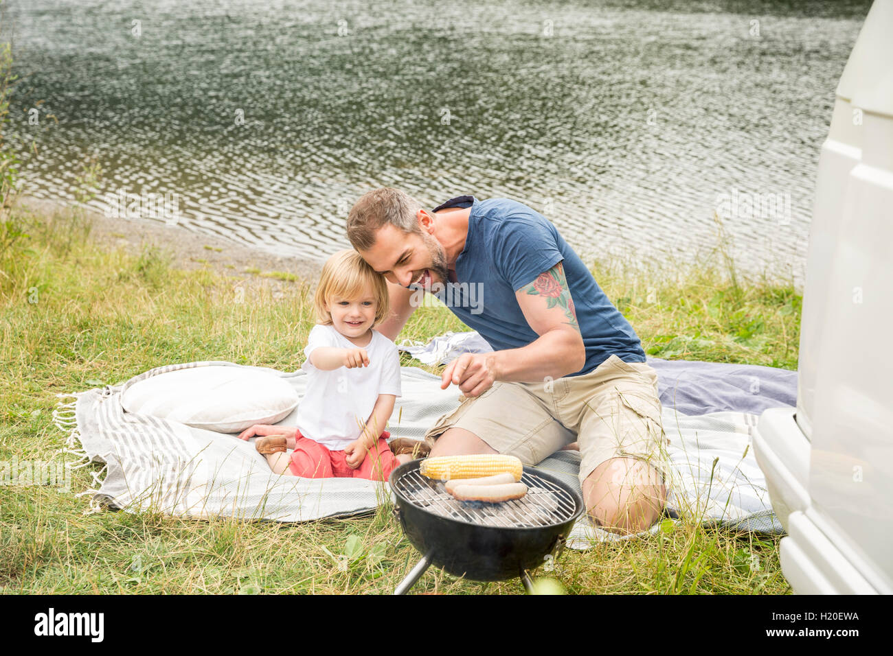 Father and son having a barbecue at lakeside Stock Photo - Alamy